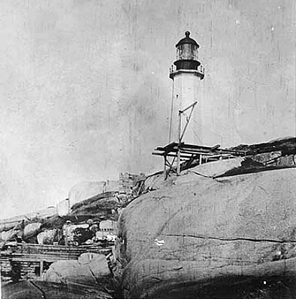Landing with derrick, lighthouse in background (1907)